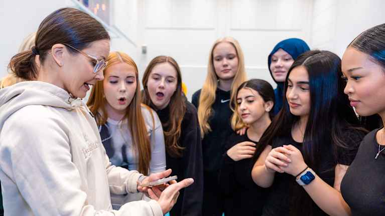 Katja Sjöblom-Korhonen näyttää kännykästään tytöille iltapukuansa linnanjuhliin.