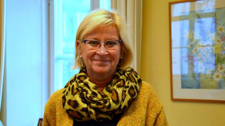 en kvinna står i sitt gula kontor med gula kläder