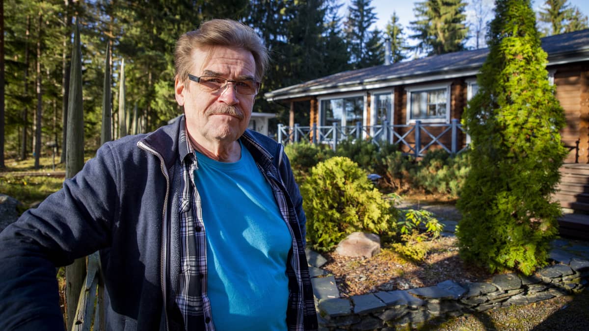 Raimo Aro on yksi monista mökkinsä taloksi muuttaneista ja taustalla on ...