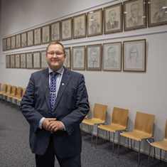 Henkilö, kaupunginjohtaja Oskari Auvinen, poseeraa kameralle kaupungintalon tiloissa. 