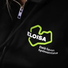 Etelä-Savon hyvinvointialueen logo Eloisan työntekijän hupparissa.