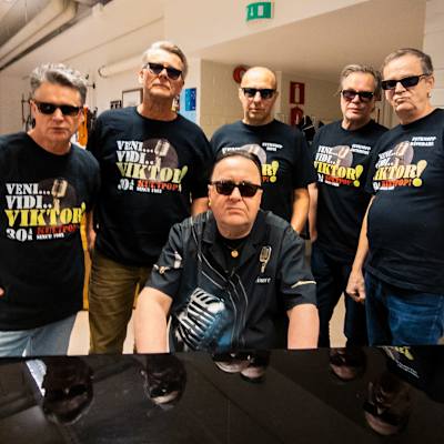 Sex män med allvarliga miner, svarta glasögon och svarta t-skjortor.